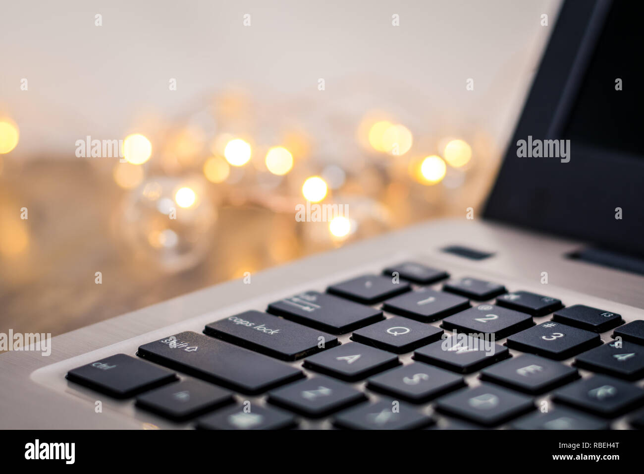 Laptop keyboard side view, selective focus, with gold tones and bokeh ...