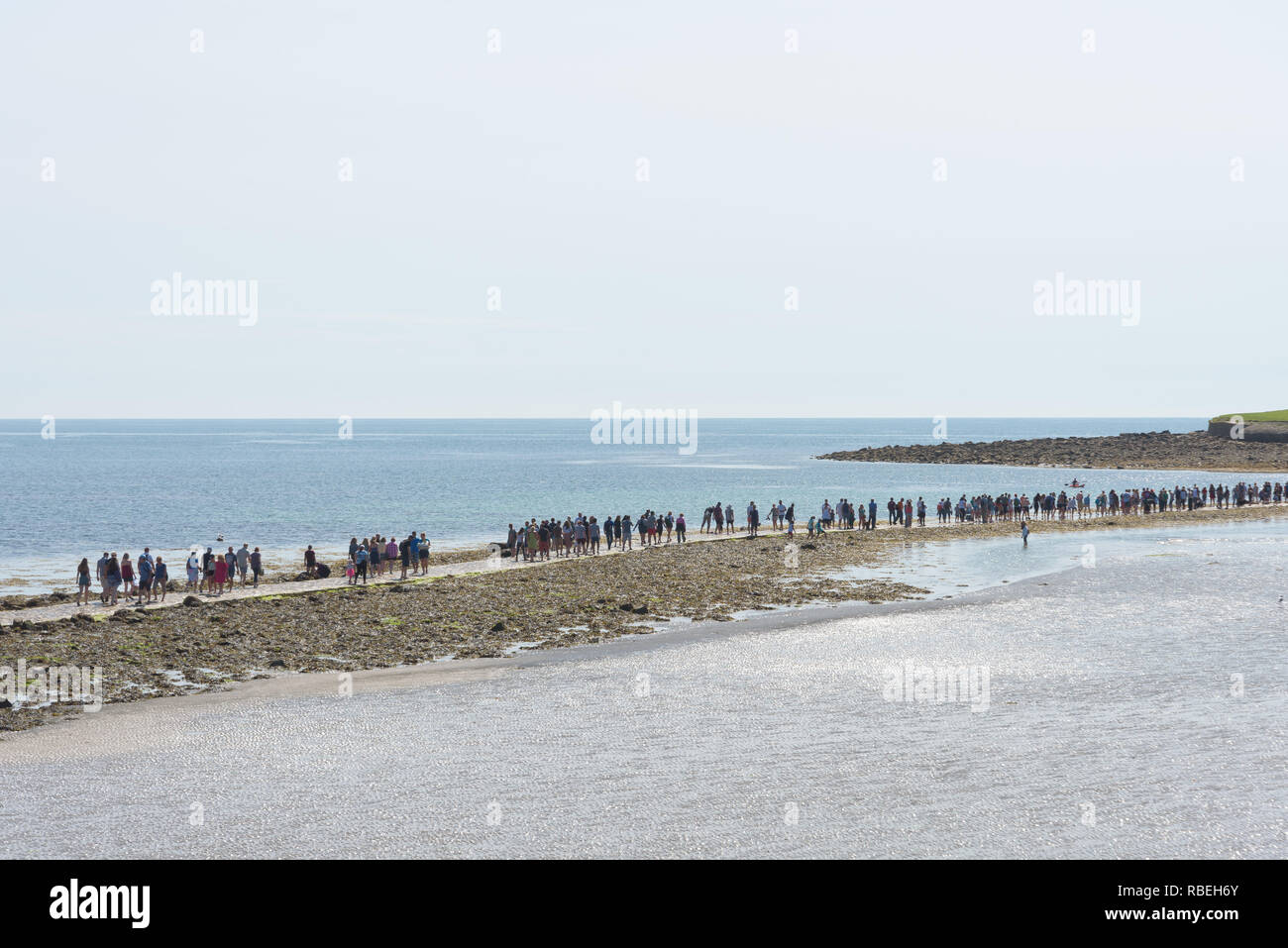Queue of people crossing the strip of land between Marazion and St ...