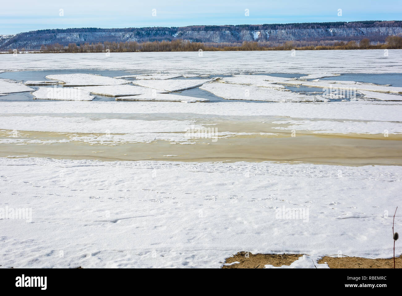 Thick ice on the river breaks into pieces under the influence of warm ...