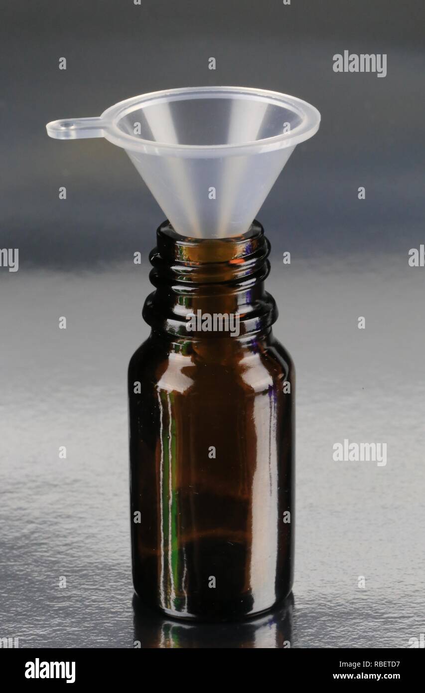 Essential oil vial filled with a funnel Stock Photo - Alamy