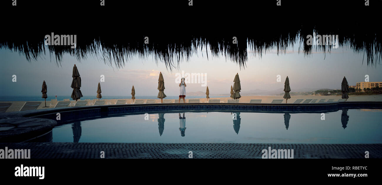 Front view of a boy standing near the swimming pool Stock Photo - Alamy