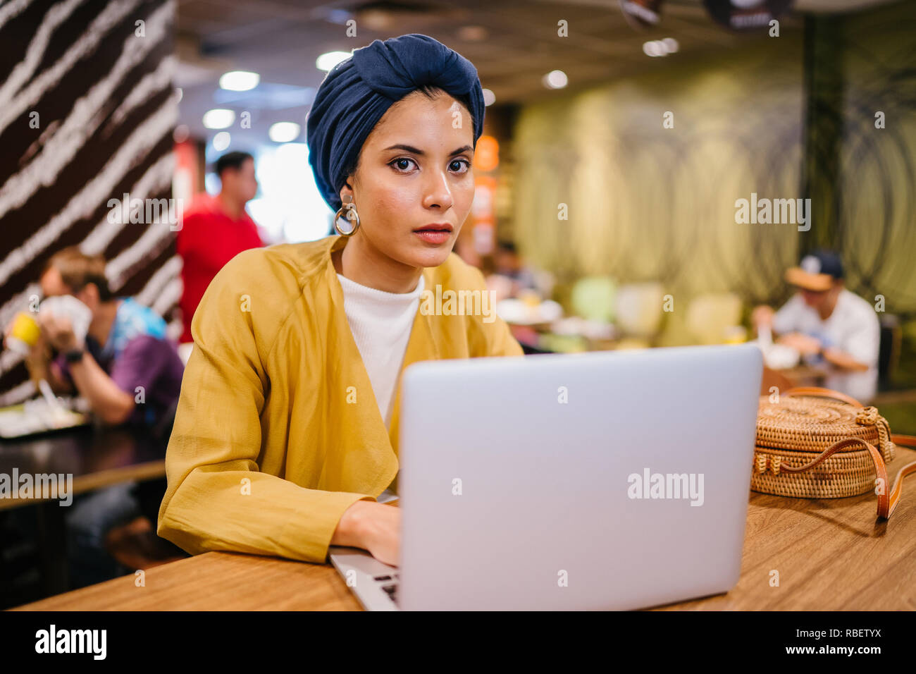 A young Malay Asian woman is typing and working or studying on her ...