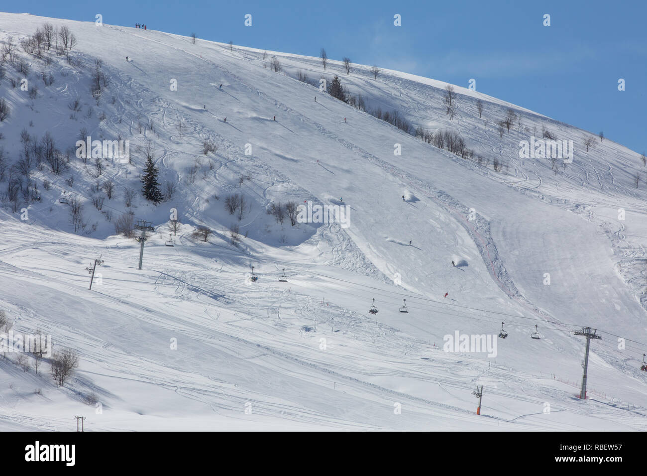 Slope of mountain resort with several skiers Stock Photo - Alamy