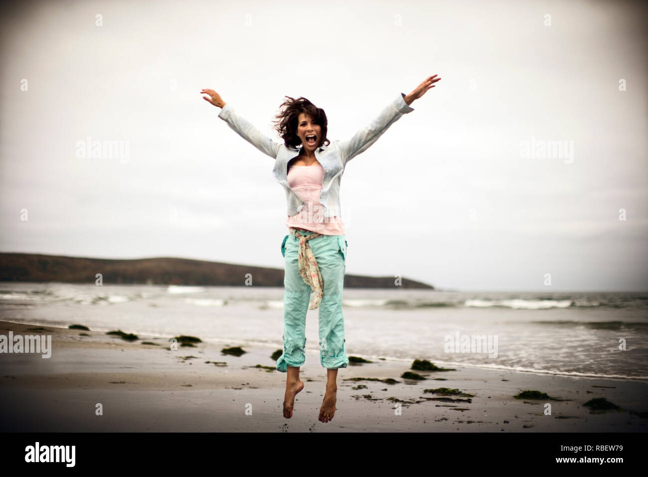 A woman jumps with her hands spread out Stock Photo - Alamy
