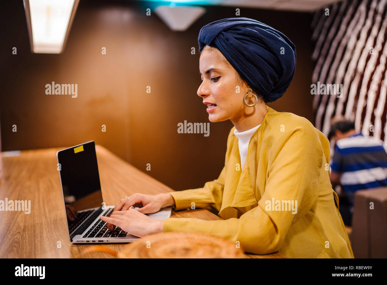 A young Malay Asian woman is typing and working or studying on her ...