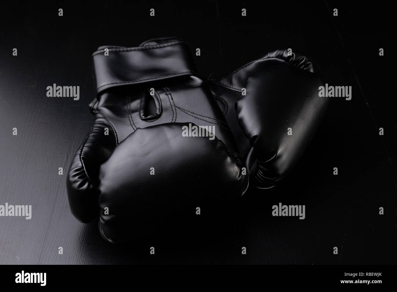 Black boxing gloves on the gym table. Training accessories. Dark ...