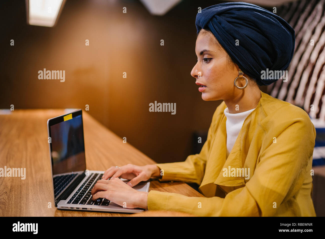 A young Malay Asian woman is typing and working or studying on her ...
