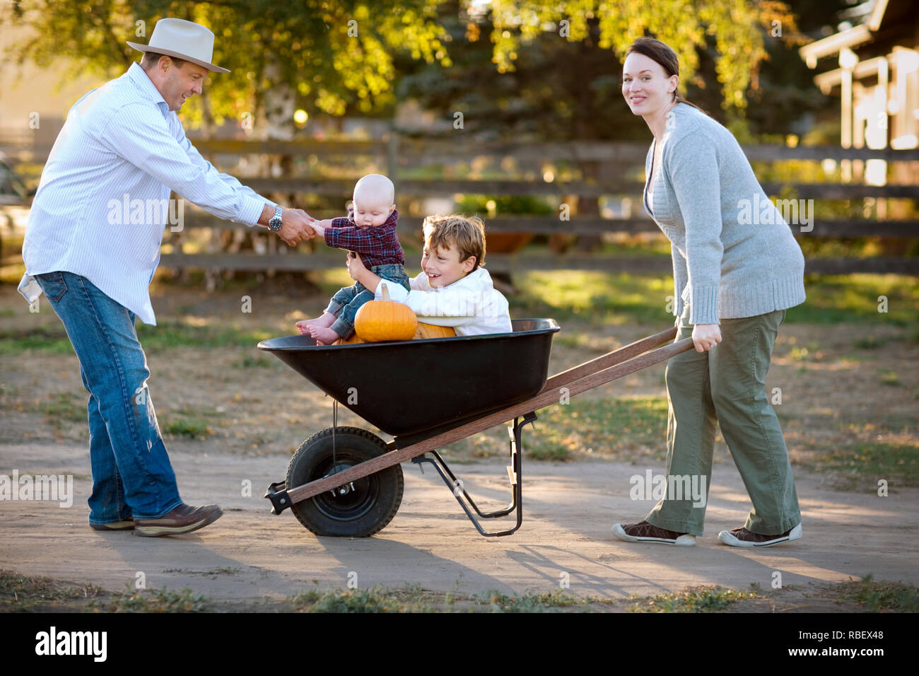 Portrait of a happy family with pumpkins and a wheelbarrow Stock Photo ...