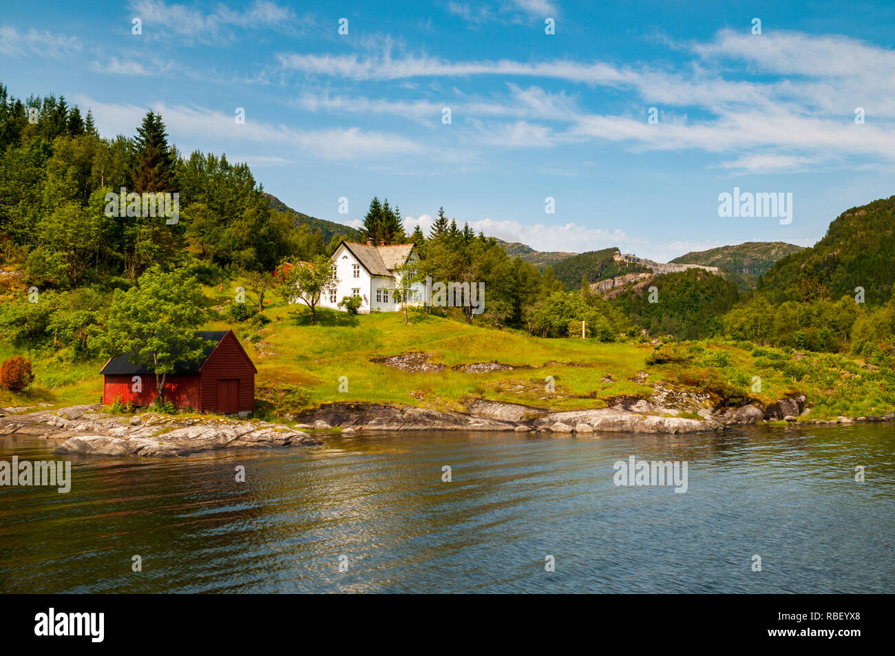 A landscape view from sea level of two Norwegian houses by the sea ...