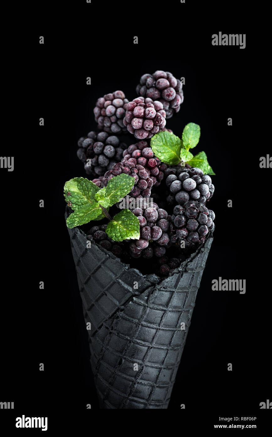 Black wafer cone with frozen blackberry fruits. Healthy ice cream Stock ...