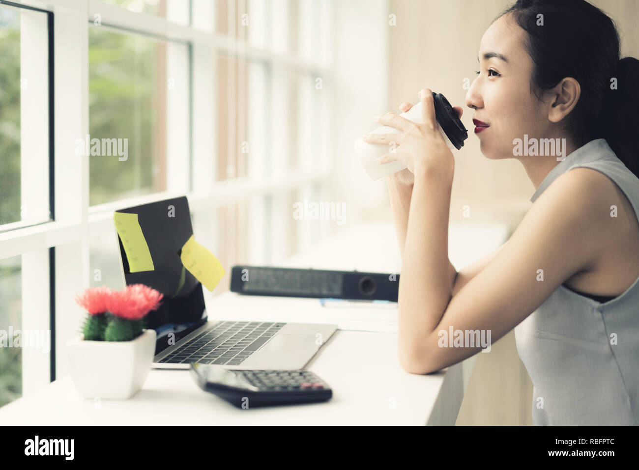 Asian business woman using laptop computer and drink coffee in cafe ...