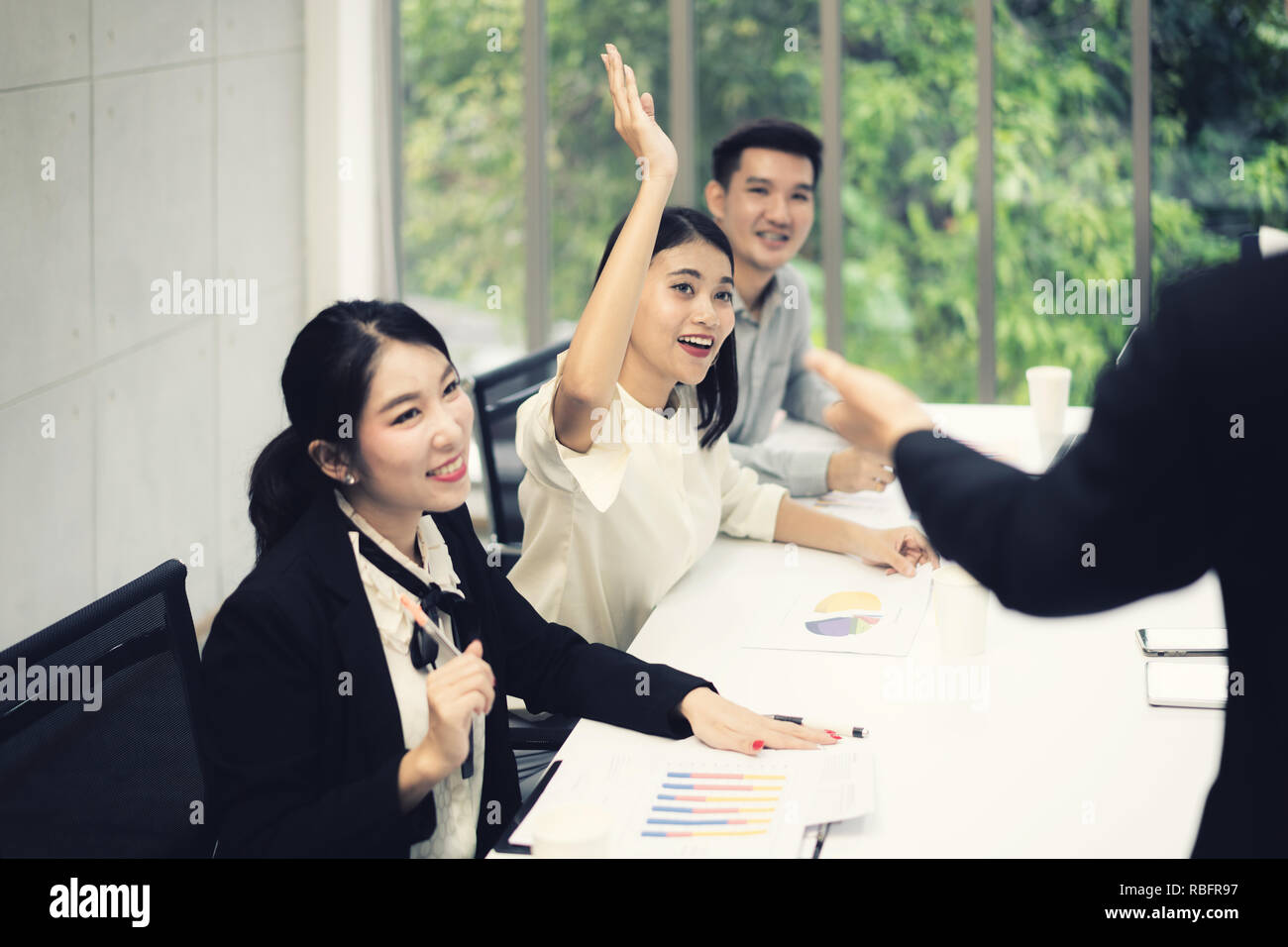 Asian woman is raising her hands has question while businessman ...