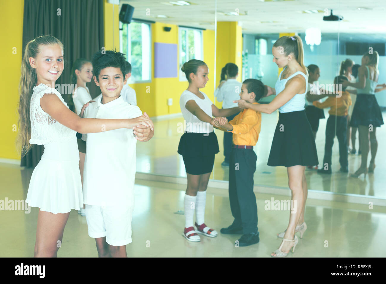 Children in dance class studying new movements, smiling and having fun ...