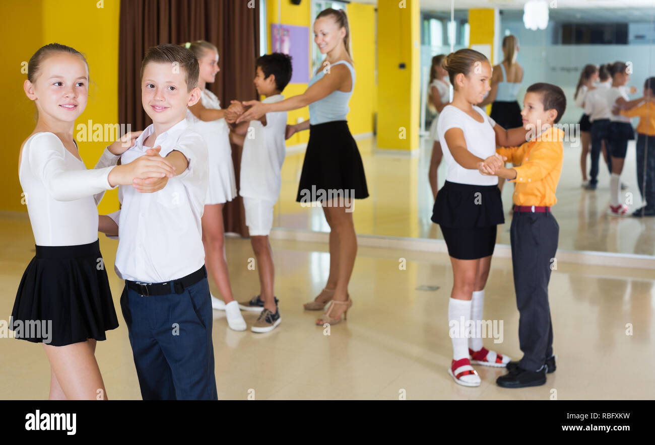 Positive active young children enjoying of partner dance in class Stock ...