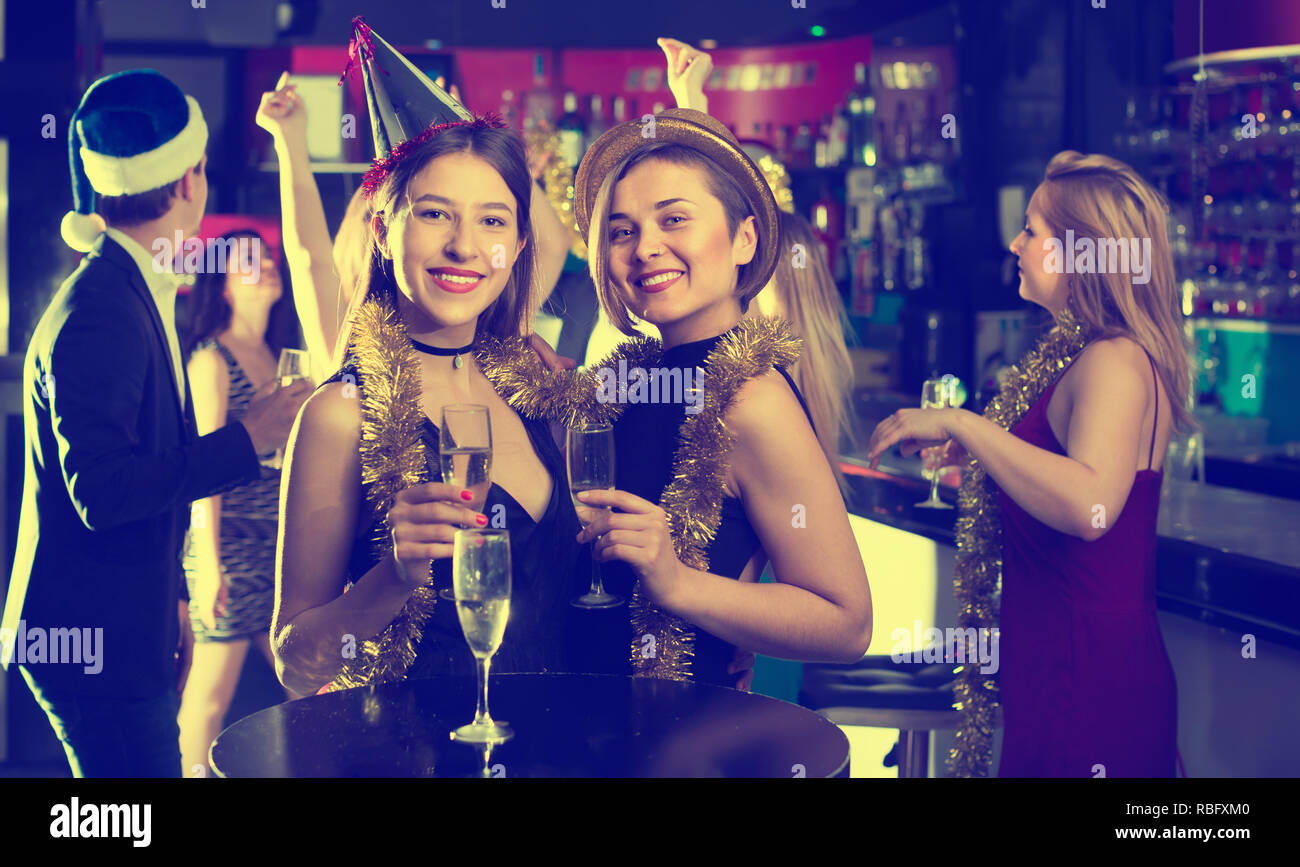 Portrait of young cheerful females and males in caps and garlands in ...