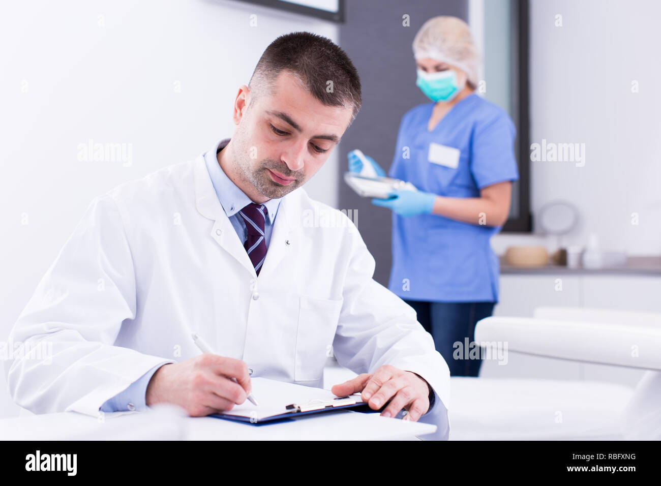 Confident doctor cosmetologist working with documents in modern ...