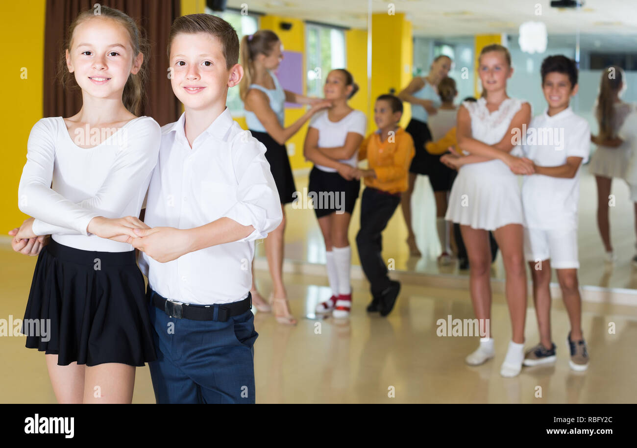 Group of positive smiling russian children dancing salsa in school ...