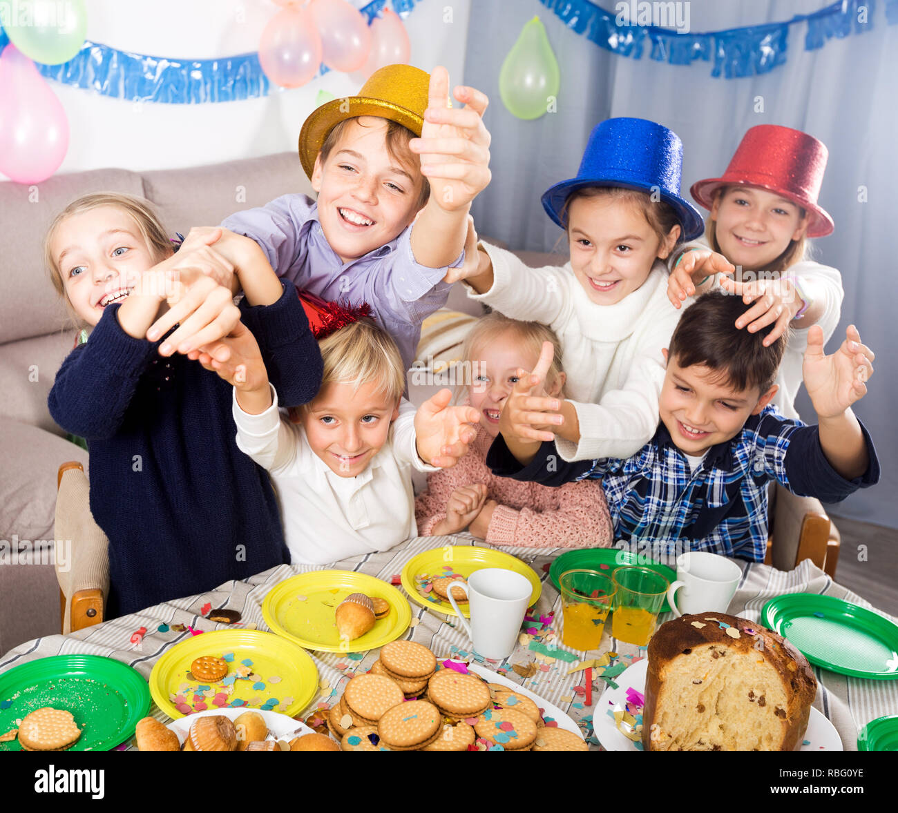 Cheerful group of children having fun during friend’s birthday party at ...