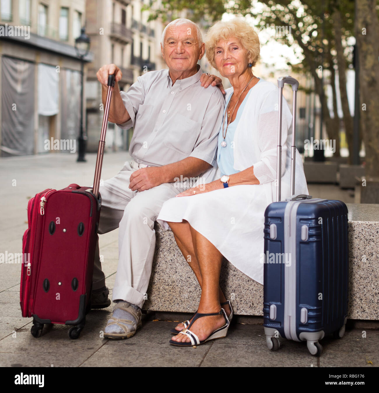 Happy loving aged spouses enjoying joint vacation sitting on bench with ...