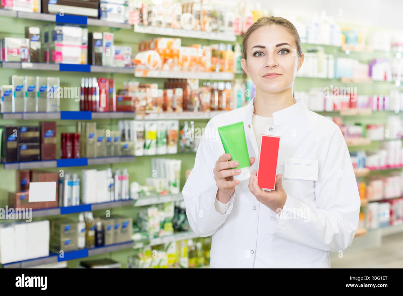 Portrait of woman pharmacist who is standing with medicine on her work ...