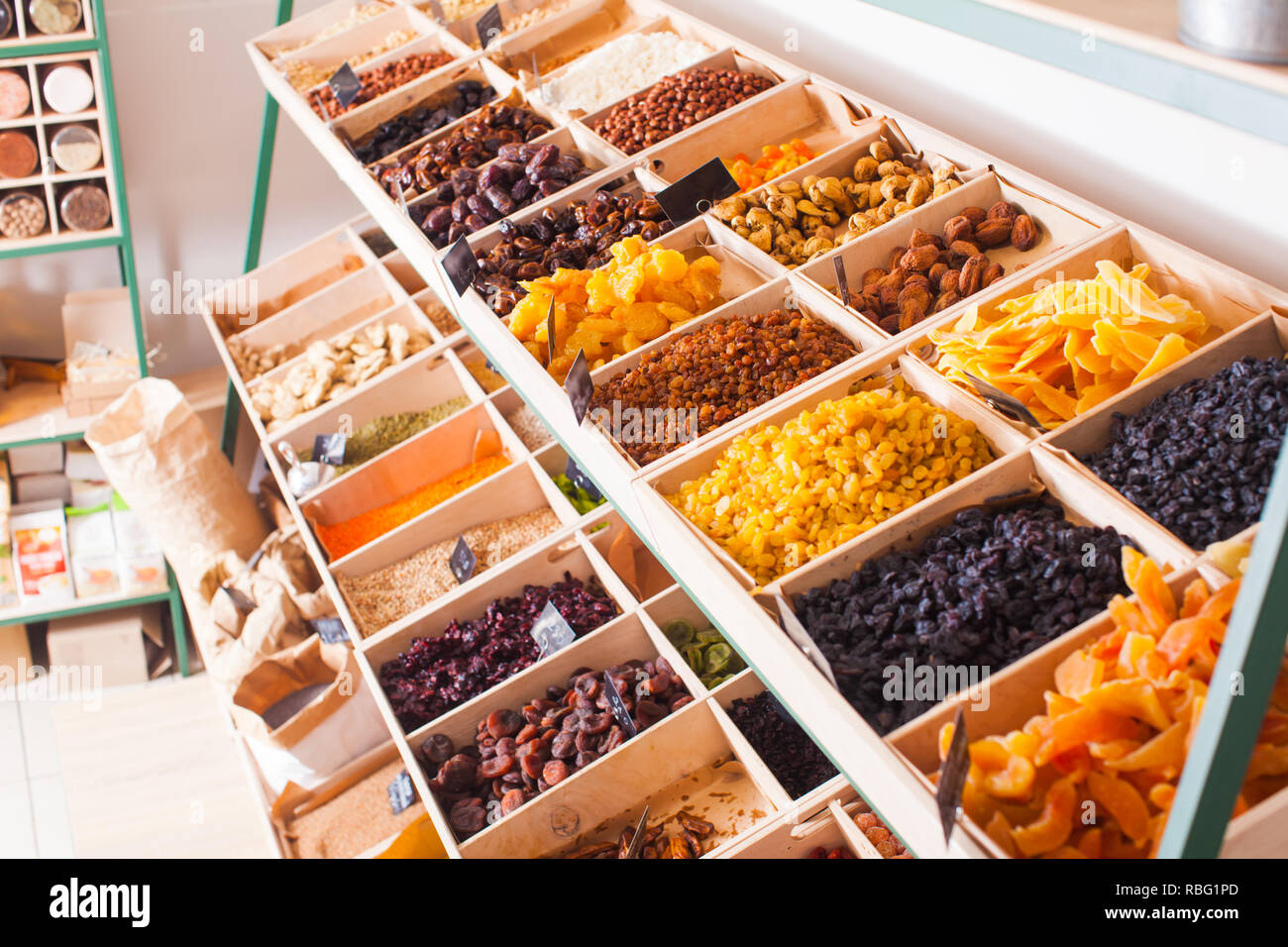 Grocery shop with wooden shelving full of organic dried fruits and ...