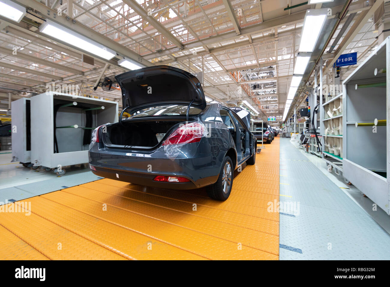 Assembled car is on the Assembly line. Robotic equipment makes the ...
