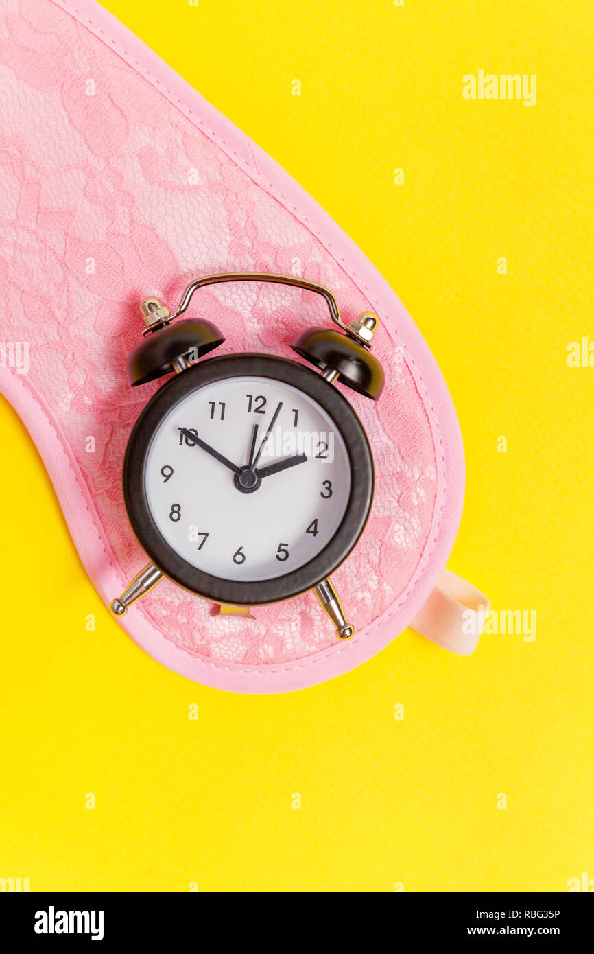 Sleeping eye mask, alarm clock isolated on yellow colourful trendy ...