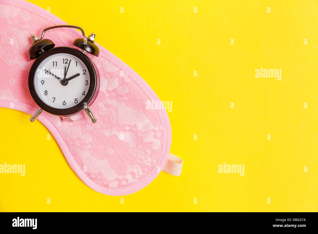 Sleeping eye mask, alarm clock isolated on yellow colourful trendy ...