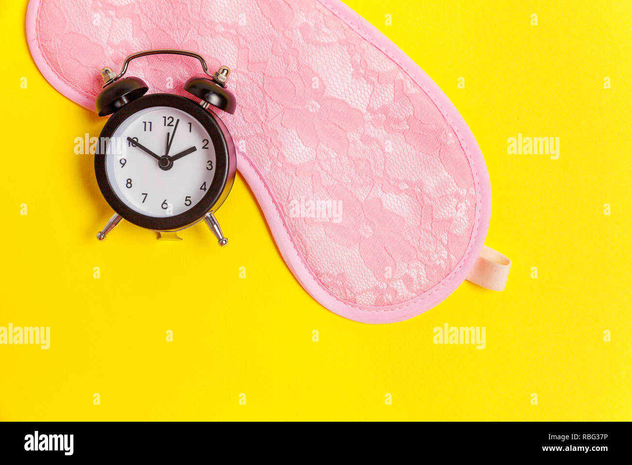 Sleeping eye mask, alarm clock isolated on yellow colourful trendy ...