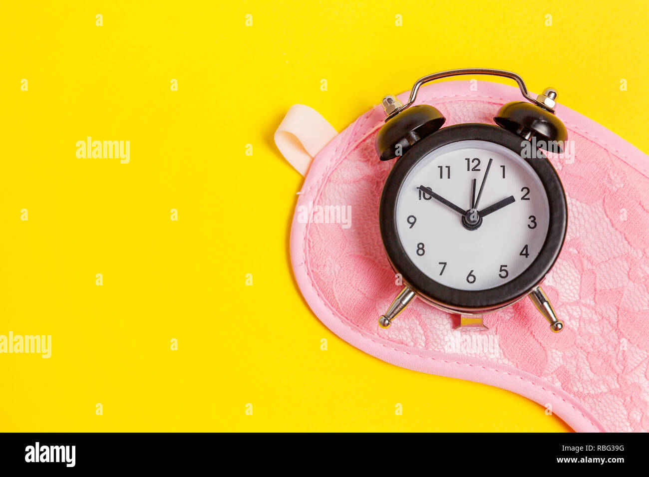 Sleeping eye mask, alarm clock isolated on yellow colourful trendy ...
