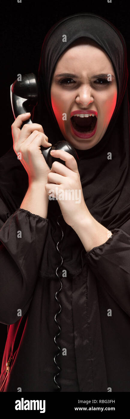 Portrait of beautiful serious scared young muslim woman wearing black ...