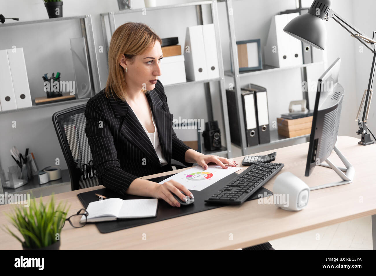 A young girl working in the office at the computer Desk Stock Photo - Alamy