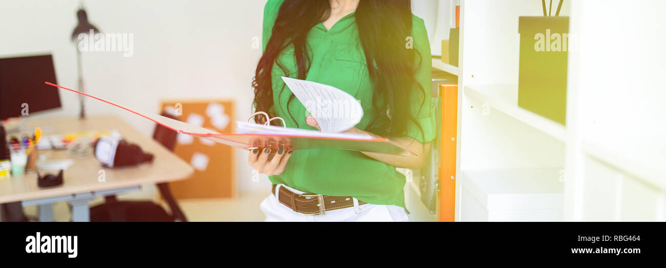 A young girl in the office is holding a folder with documents Stock ...