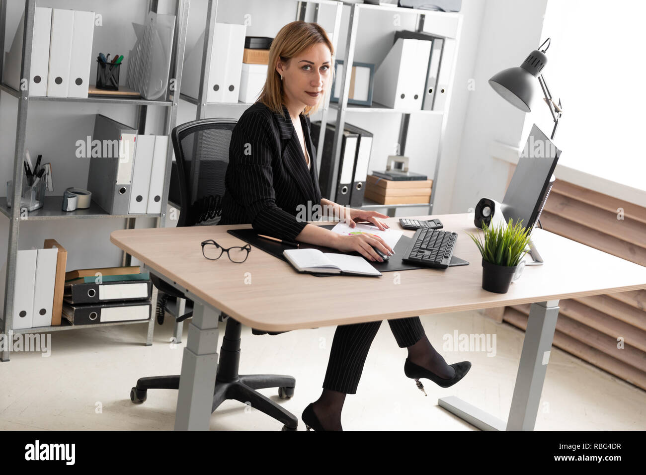 A young girl working in the office at the computer Desk Stock Photo - Alamy