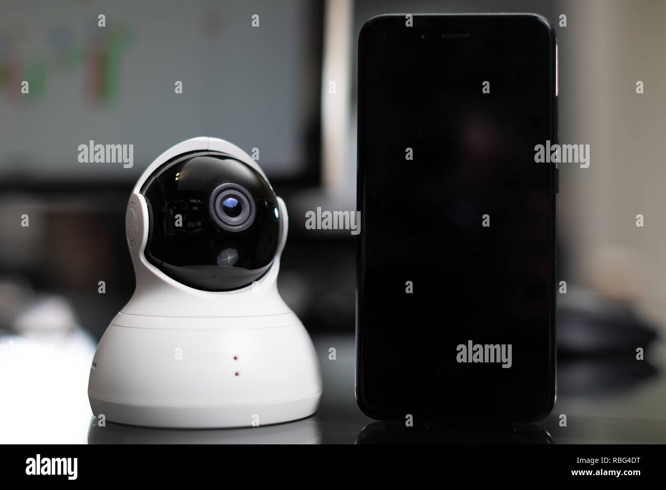 webcam and mobile phone with blank black screen on dark background ...