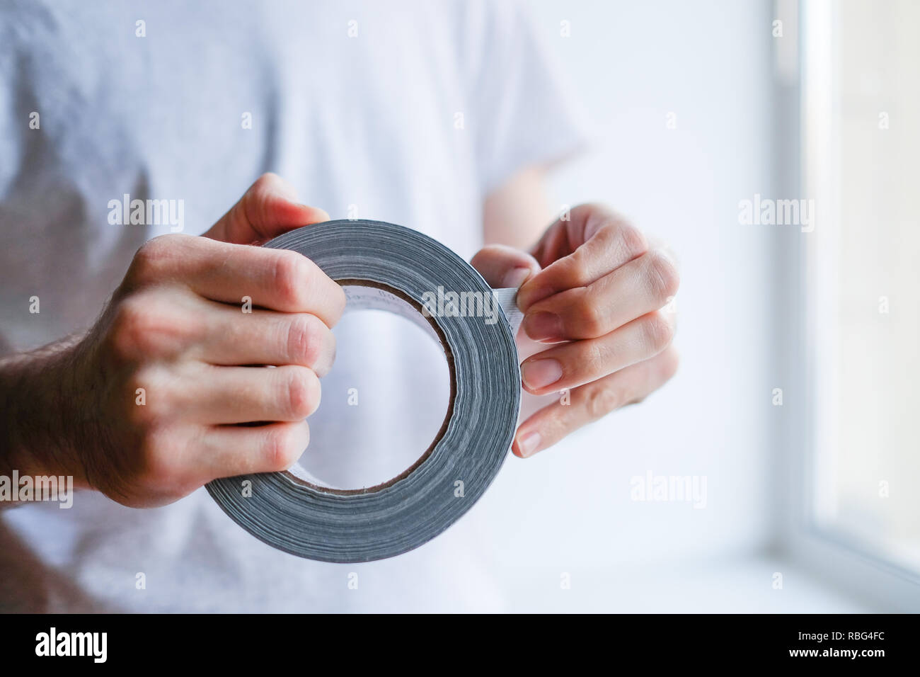 Worker putting sealing tape on window in house Stock Photo - Alamy