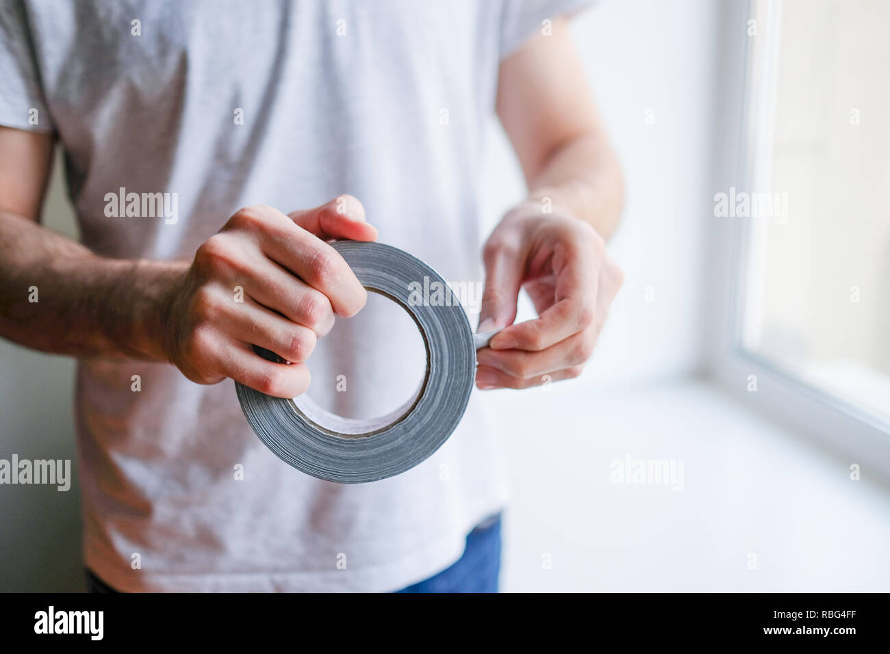 Worker putting sealing tape on window in house Stock Photo - Alamy