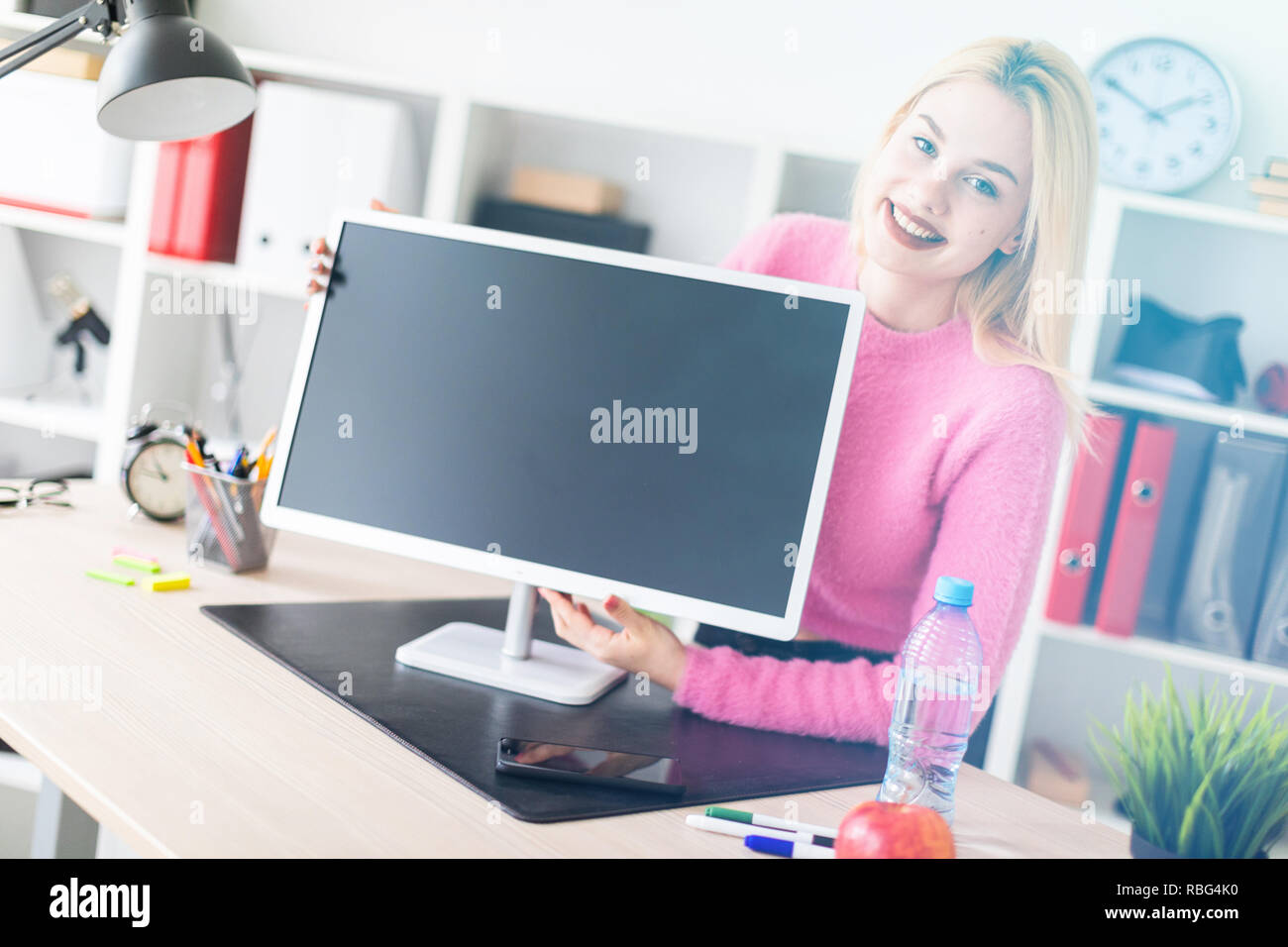 A young girl standing in the office with a monitor Stock Photo - Alamy
