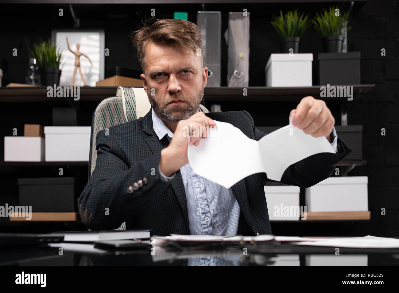 Businessman sitting at computer table and tears document Stock Photo ...