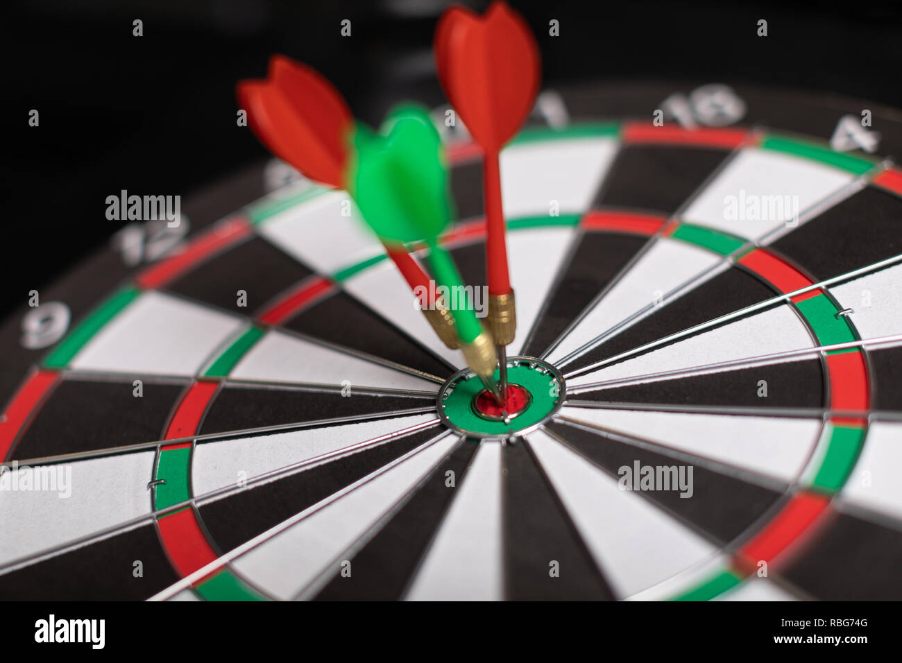 Three Darts hit red target close-up Stock Photo - Alamy