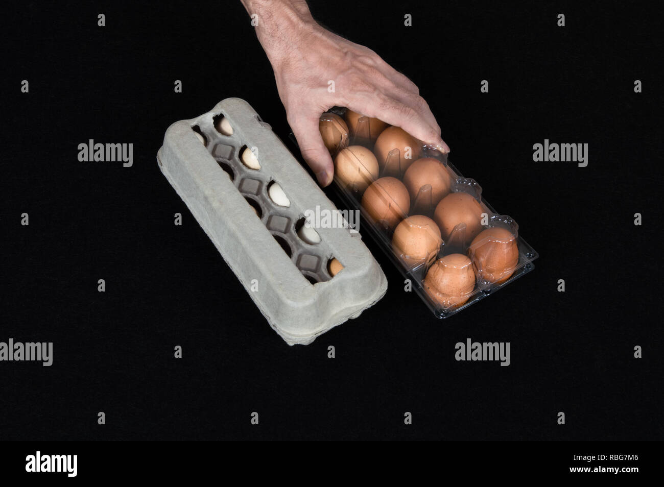 Male hand picking a plastic egg box instead of carton box full of hen ...