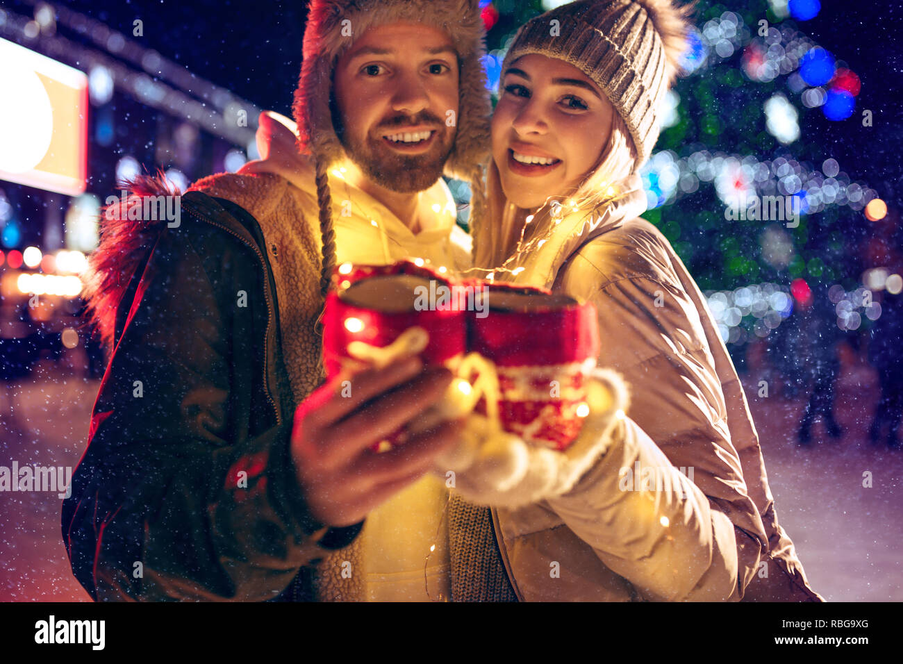 Adult couple hanging out in the city during Christmas time over lights ...