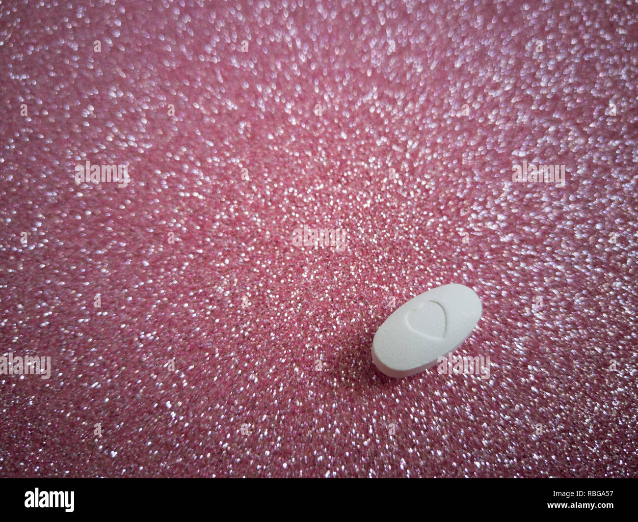White pill with heart shape, love shape medicine isolated on glitter ...