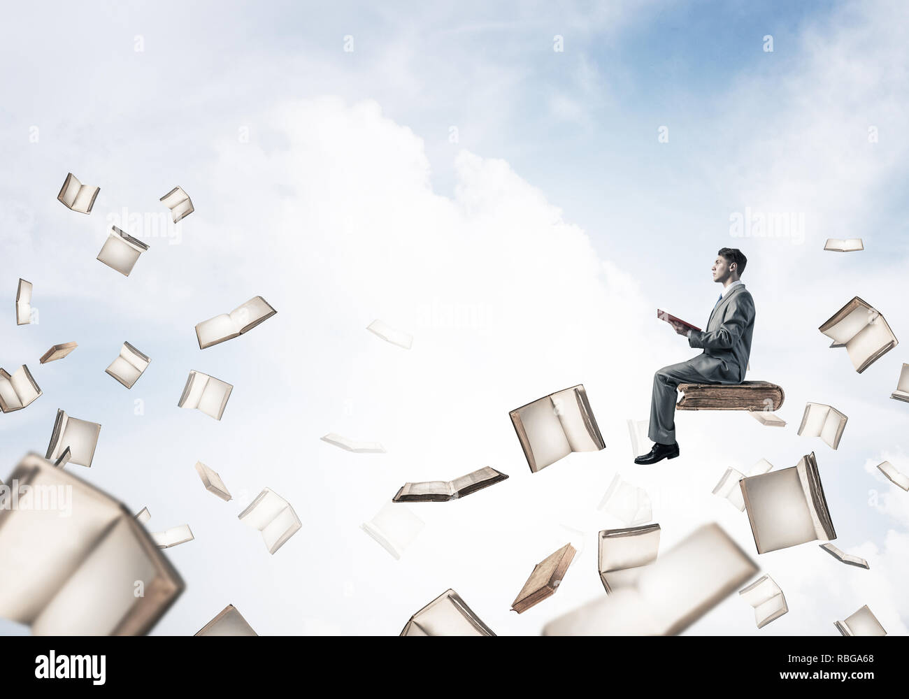 Man reading book and many of them flying in air Stock Photo - Alamy