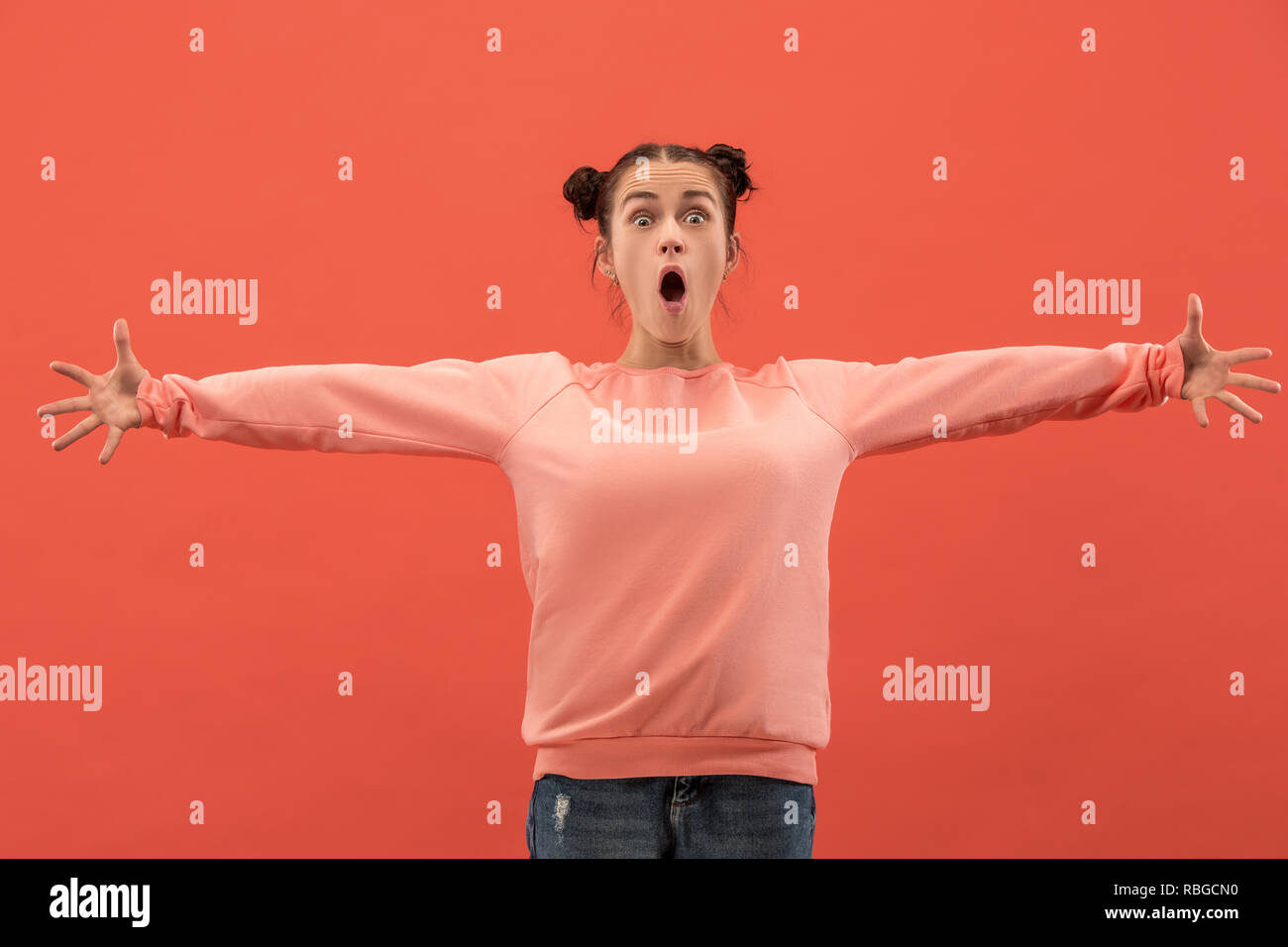 Delight. Beautiful female half-length front portrait isolated on coral ...