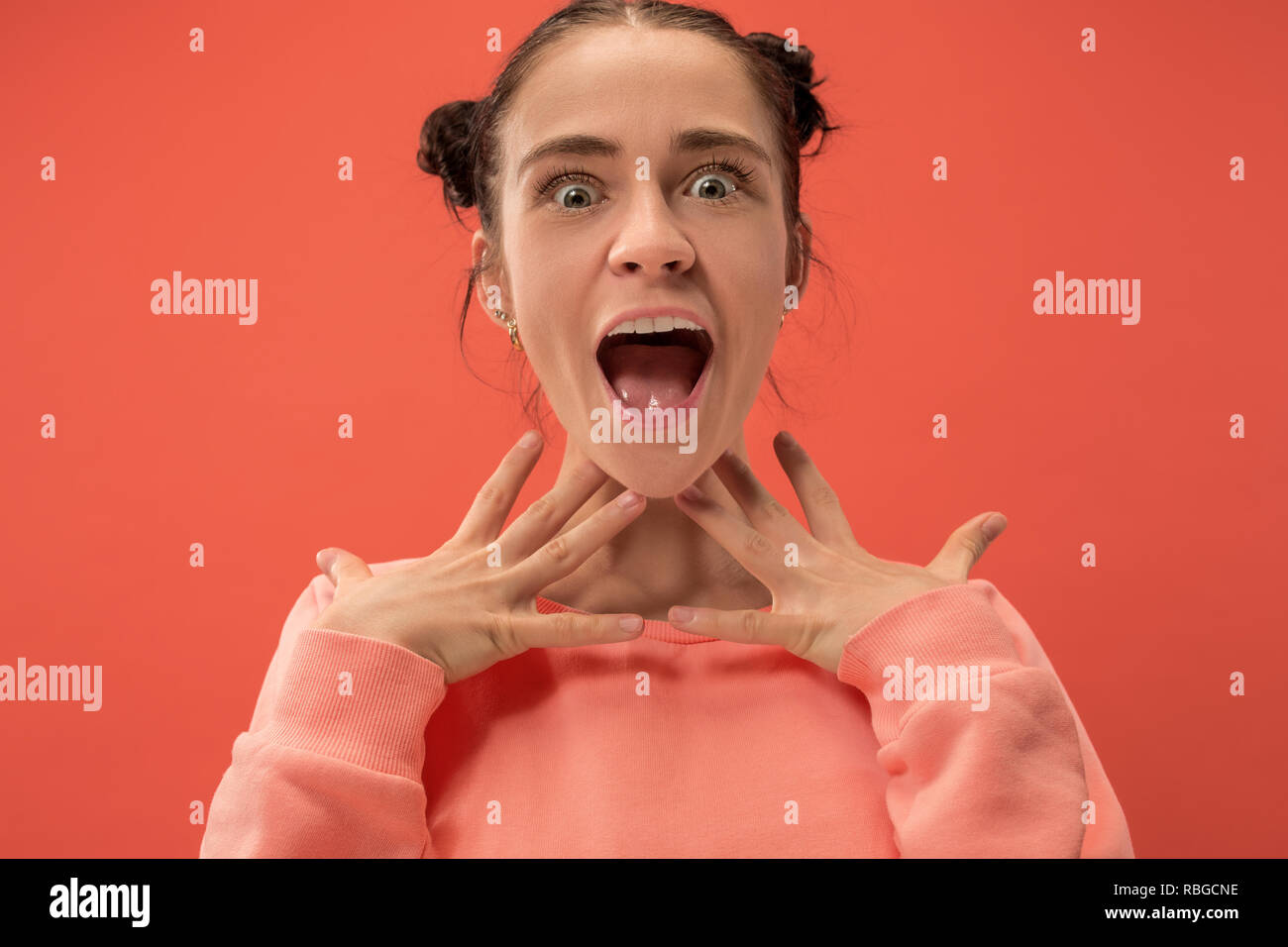 Delight. Beautiful female half-length front portrait isolated on coral ...