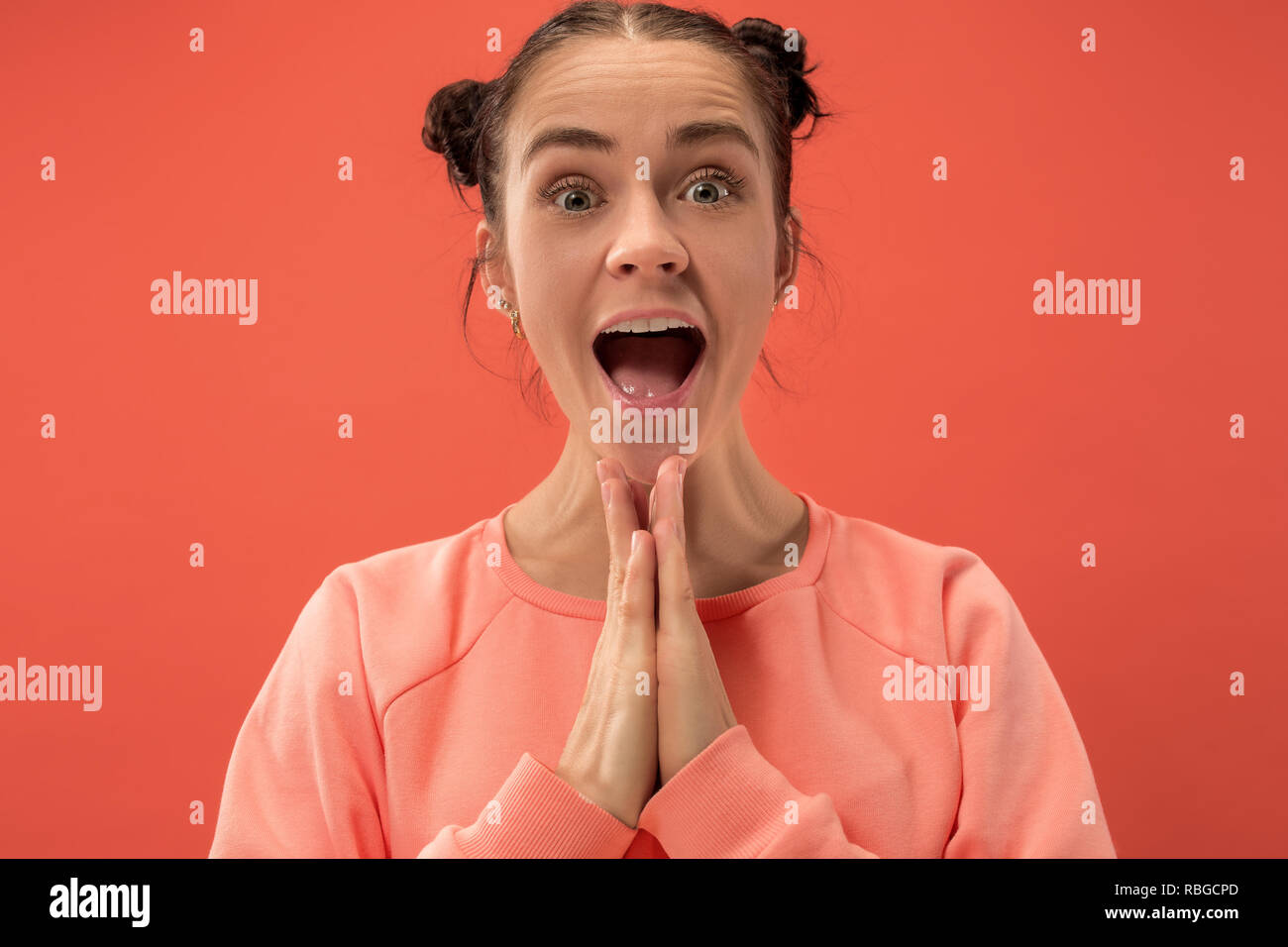 Delight. Beautiful female half-length front portrait isolated on coral ...