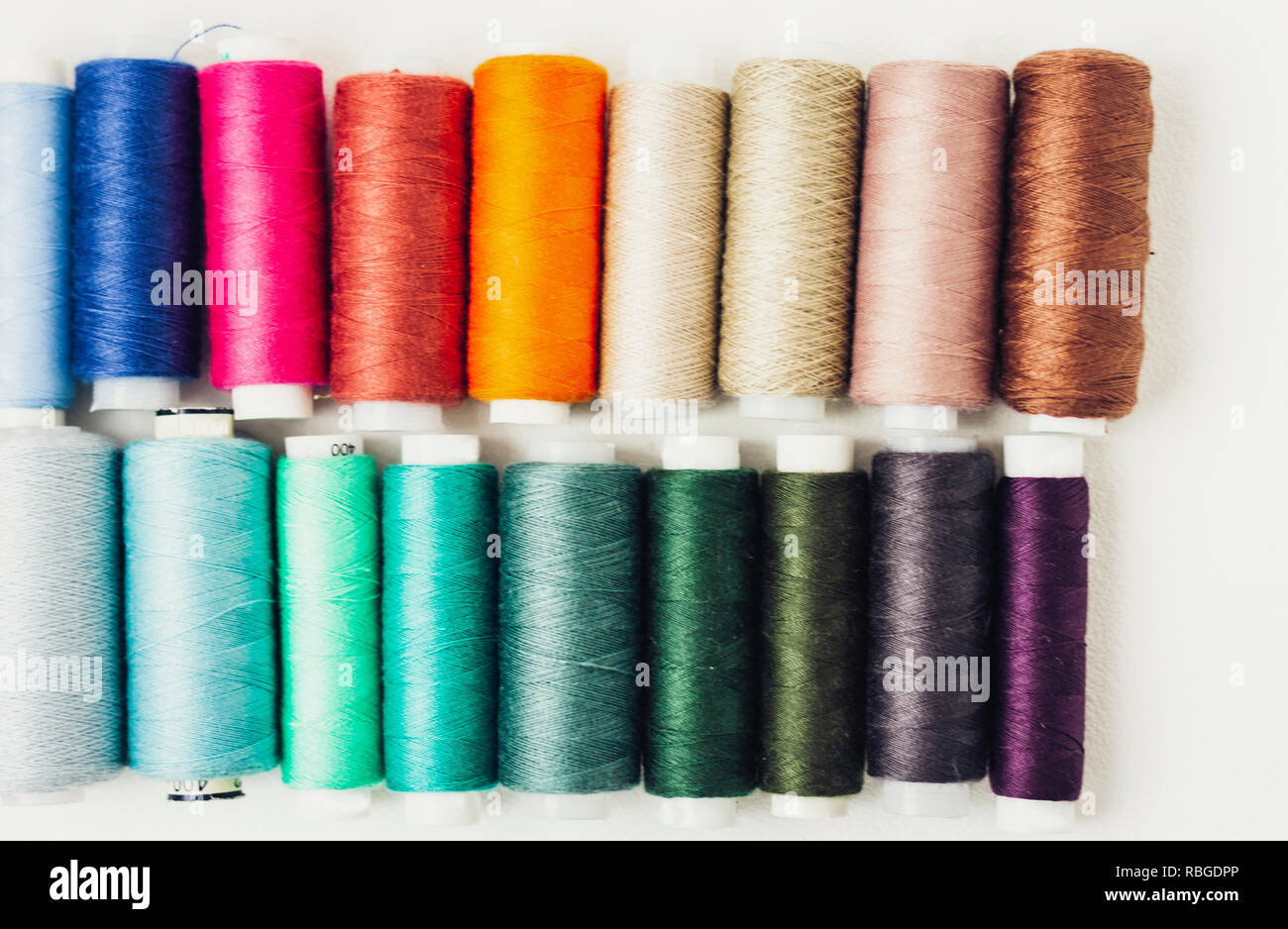 Colored sewing thread coils on white background with copy space for ...