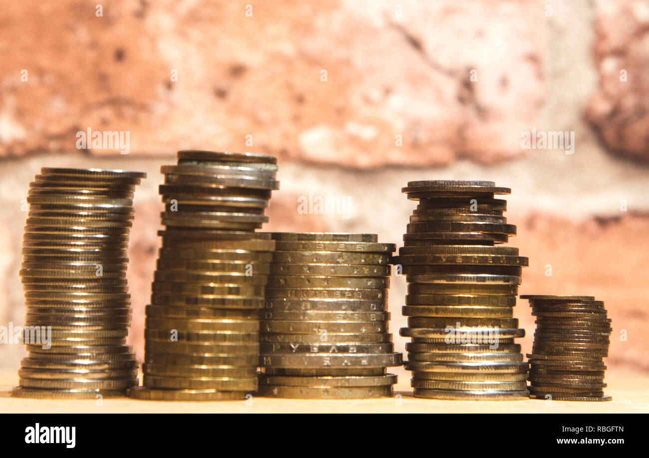 Stacks of coins and a vintage brick wall reverse Stock Photo - Alamy