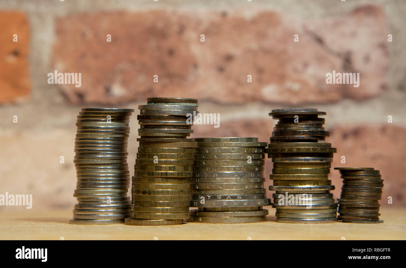 Stacks of coins and a vintage brick wall reverse Stock Photo - Alamy